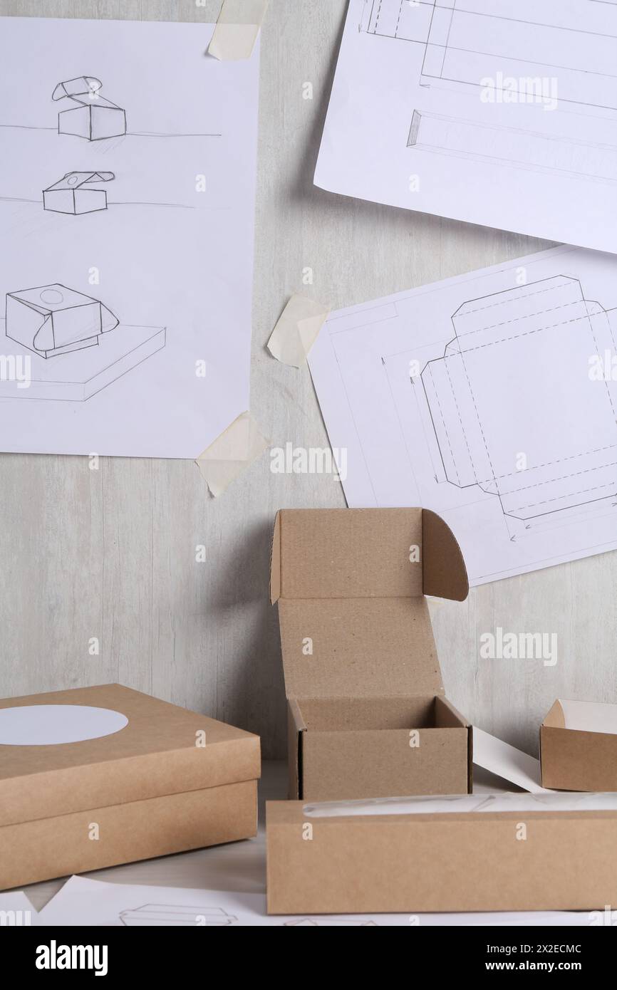 Creating packaging design. Drawings and boxes on table, closeup Stock ...