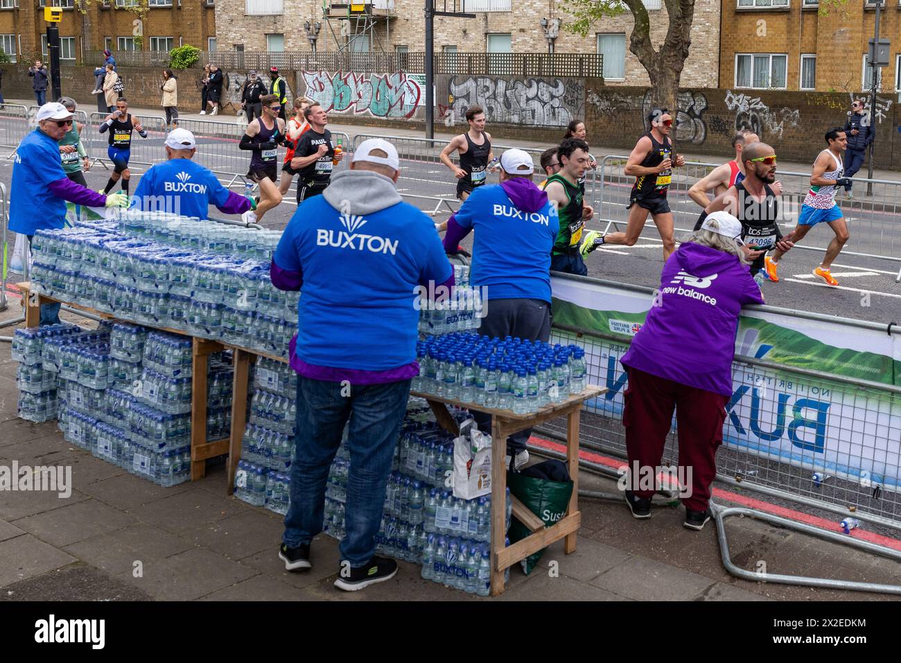 London, UK. 21st April, 2024. Volunteers distribute water to runners ...