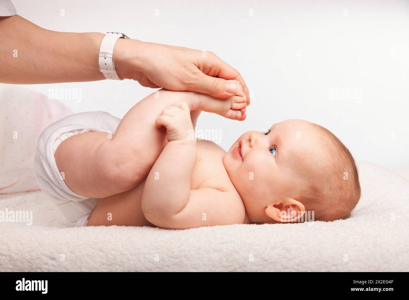Physiotherapist performing development exercise with three month baby ...