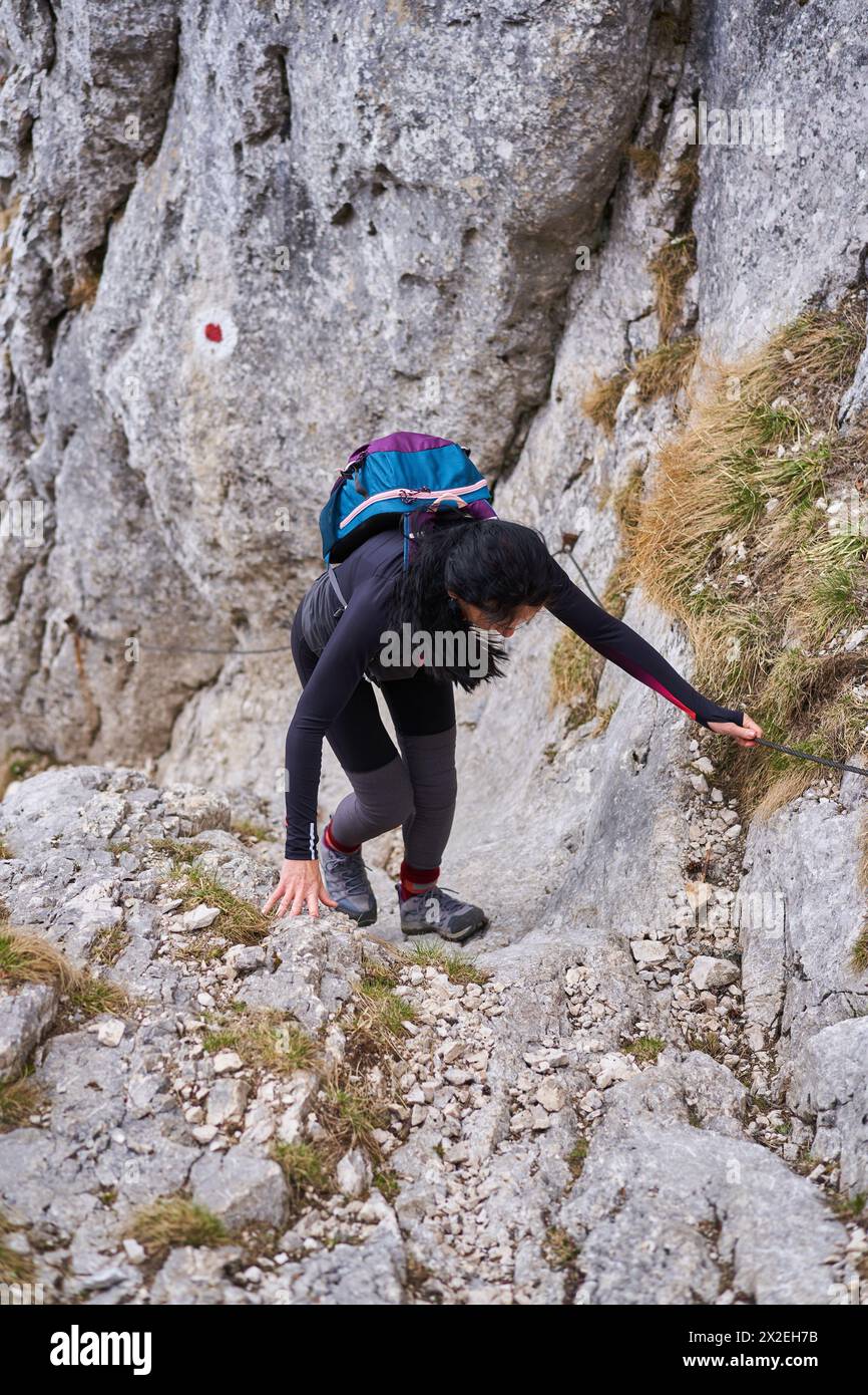 Mountaineer woman climbing a steep wall on safety line Stock Photo - Alamy