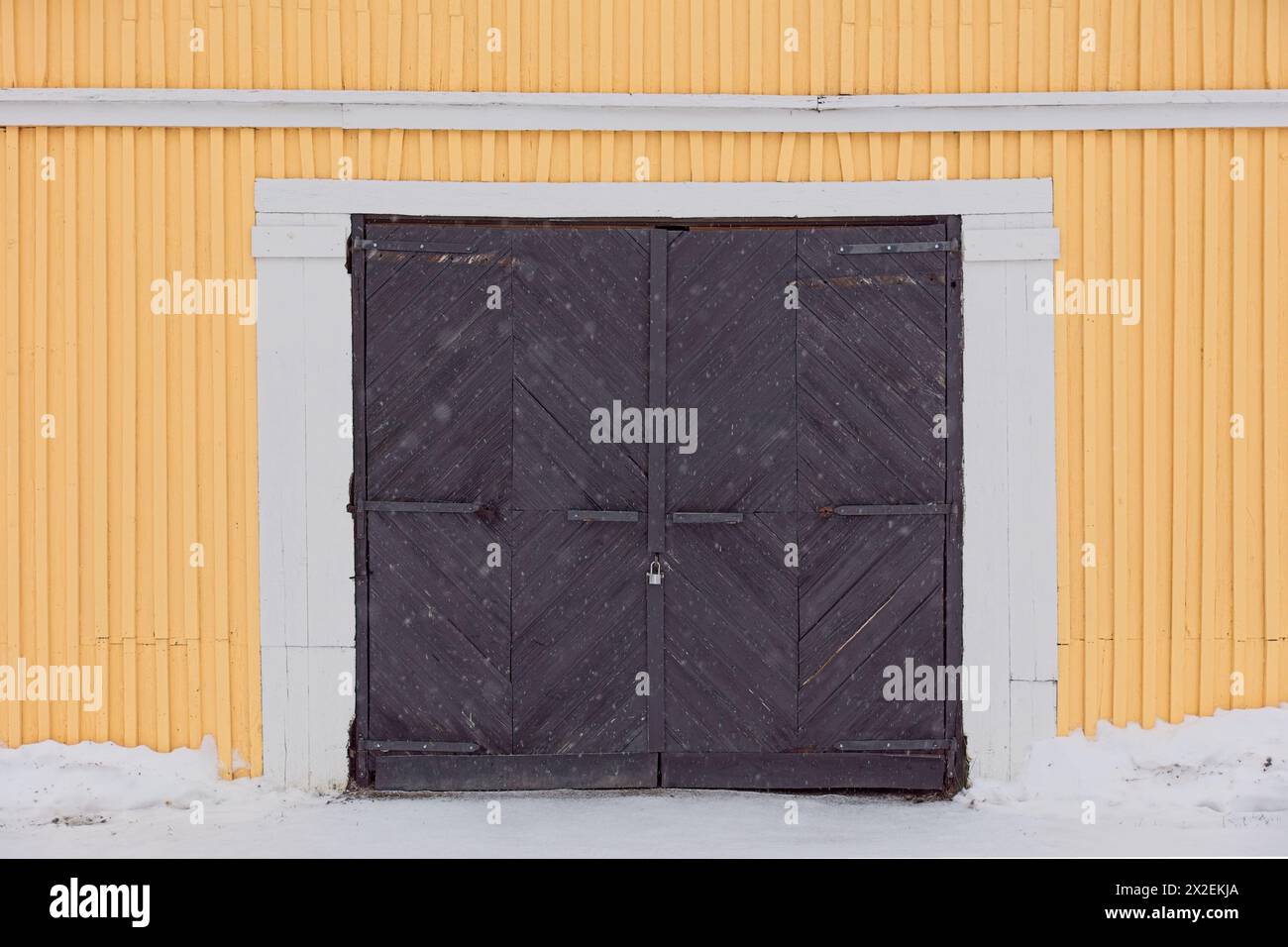 Closed double barn doors with white frame on a yellow wall Stock Photo ...