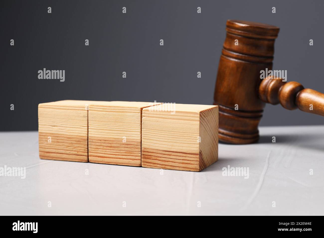 Law. Blank wooden cubes and gavel on light table against gray ...