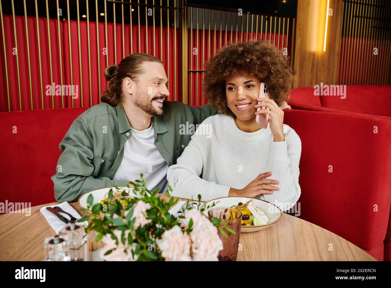 An African American woman and a man deeply engaged in cell phone ...