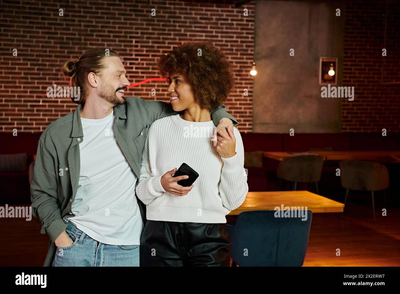 An African American woman and a man of varying descent stand side by ...