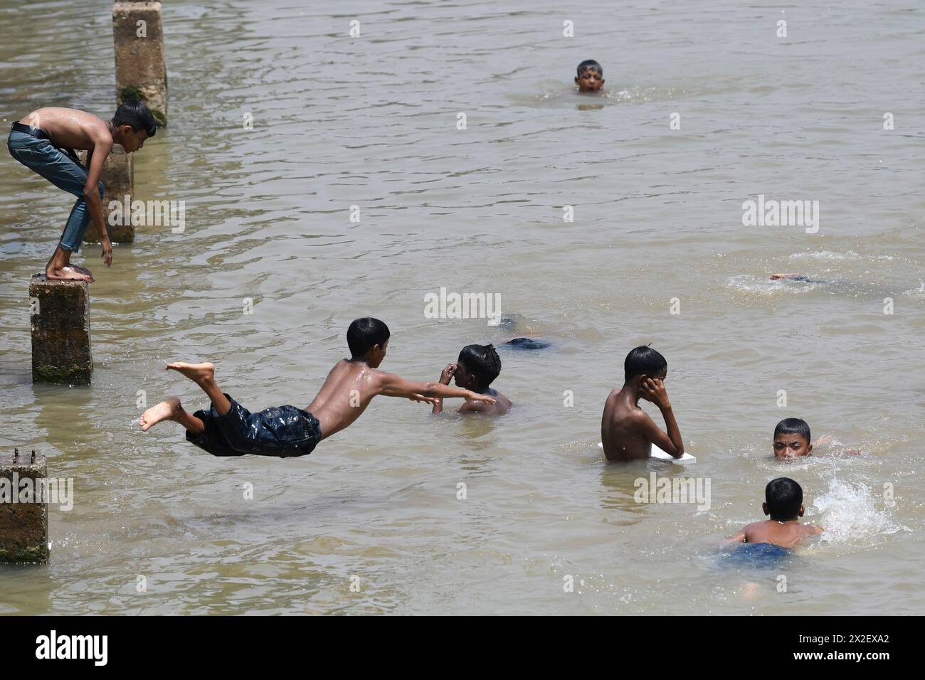 Dhaka, Bangladesh. 22nd Apr, 2024. Kids cool off in a lake on a hot day ...
