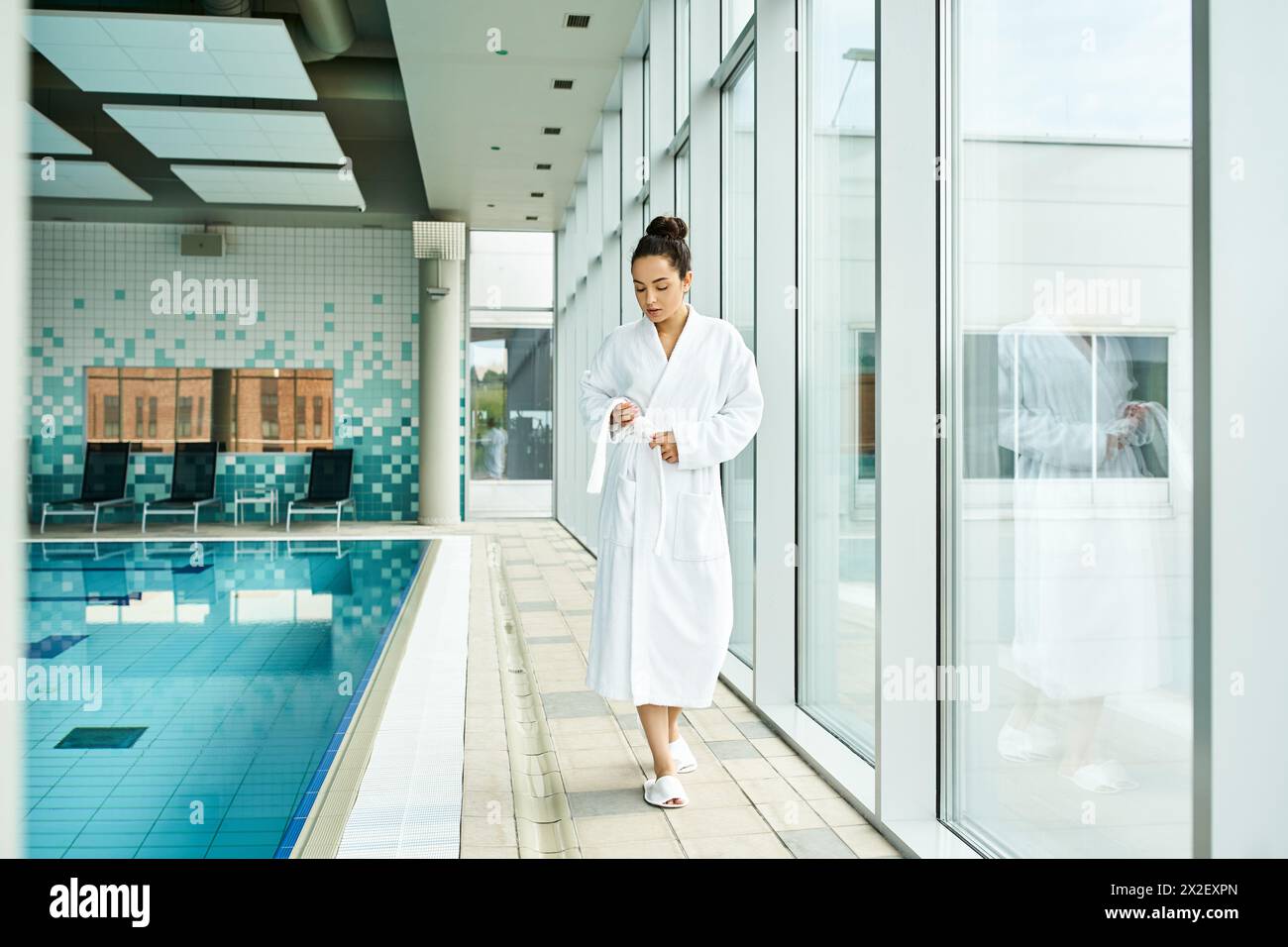 A young, beautiful brunette woman in a bathrobe standing beside an ...