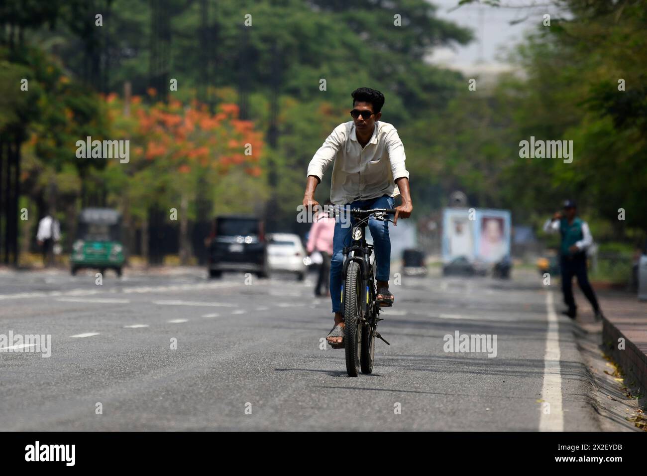 Dhaka, Bangladesh. 22nd Apr, 2024. A man rides a bicycle along a street ...
