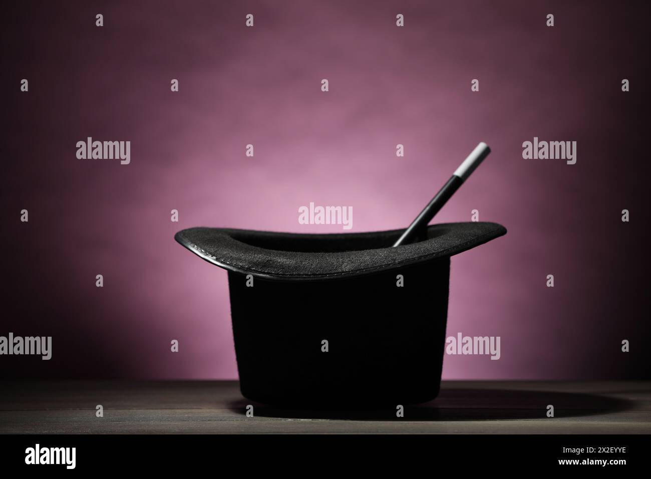 Magician's hat and wand on wooden table against dark background Stock ...
