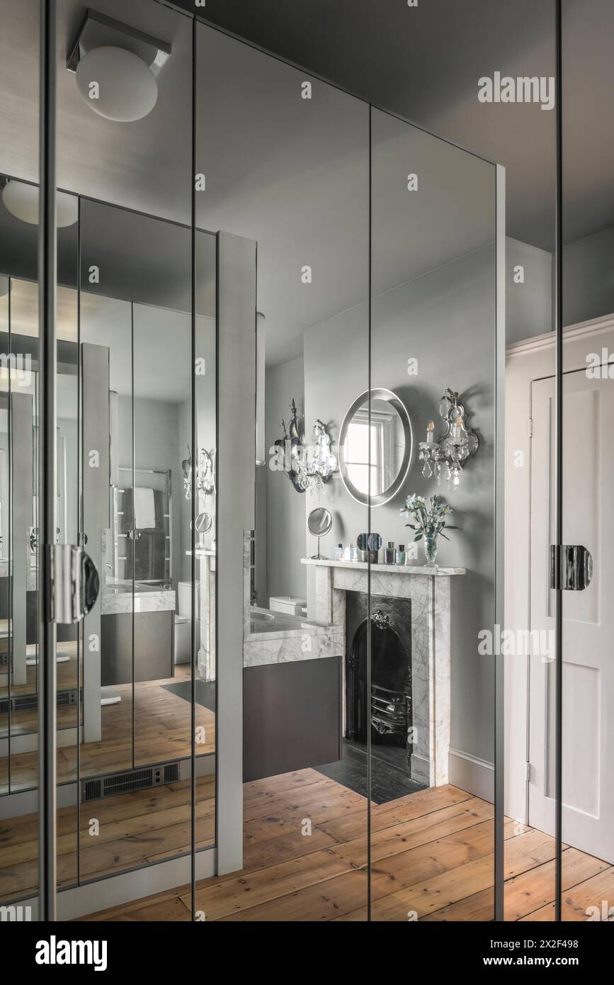 Mirrored wardrobe reflecting fireplace in renovated Georgian townhouse ...
