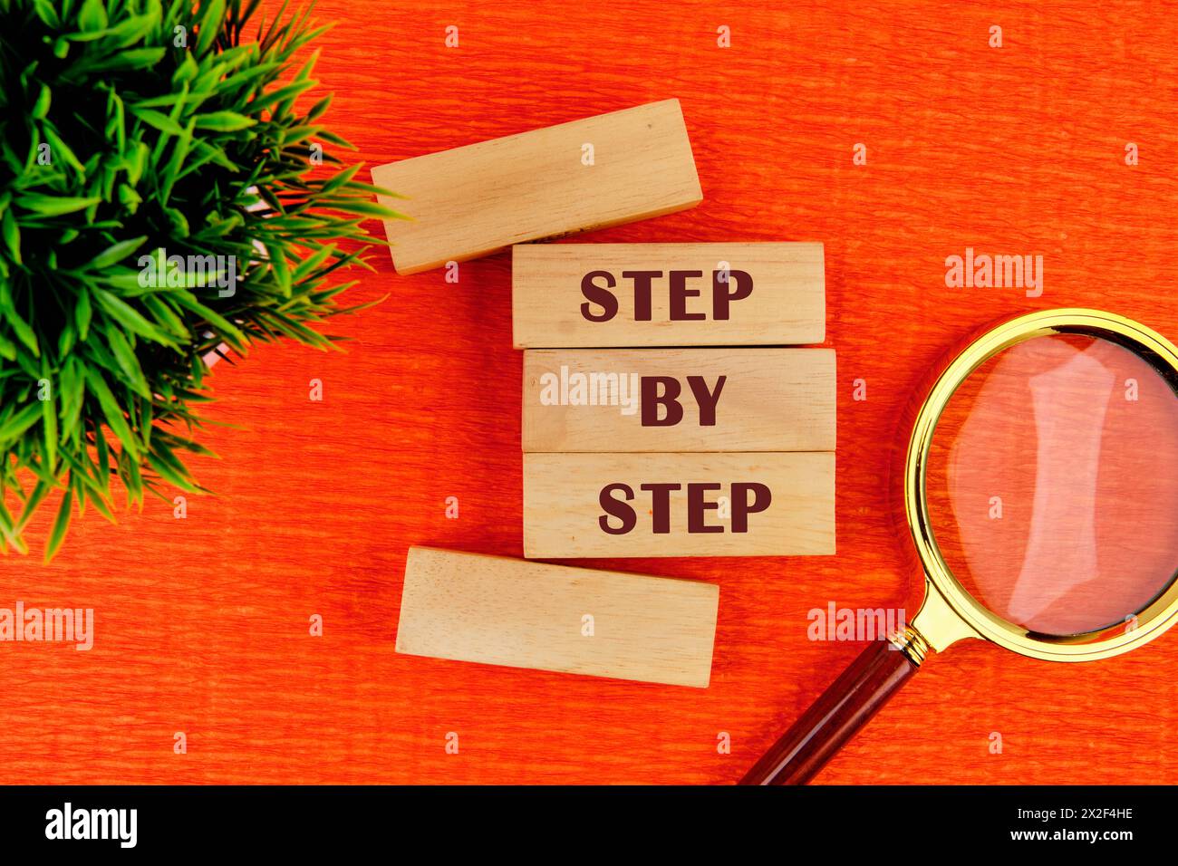 Concept Step by Step text on wooden blocks on a red background near a ...