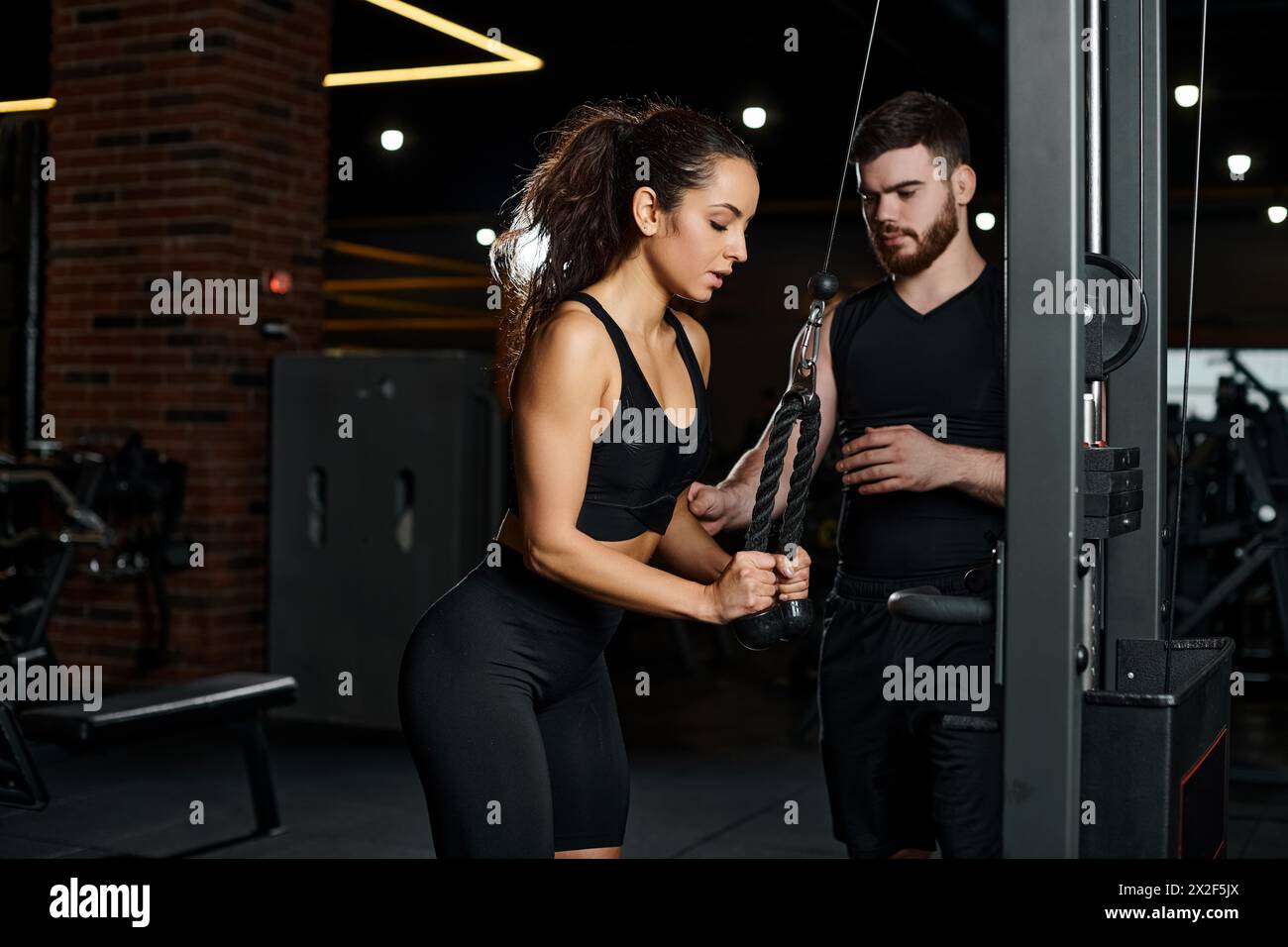 A personal trainer is guiding a brunette sportswoman through a workout ...