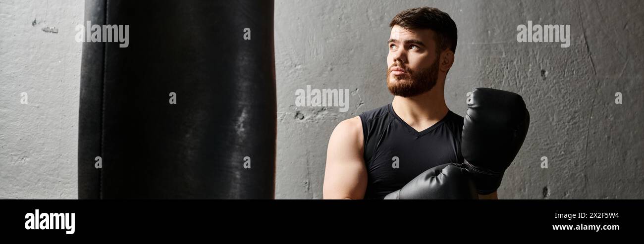 Handsome man with beard wearing black tank top and boxing gloves ...