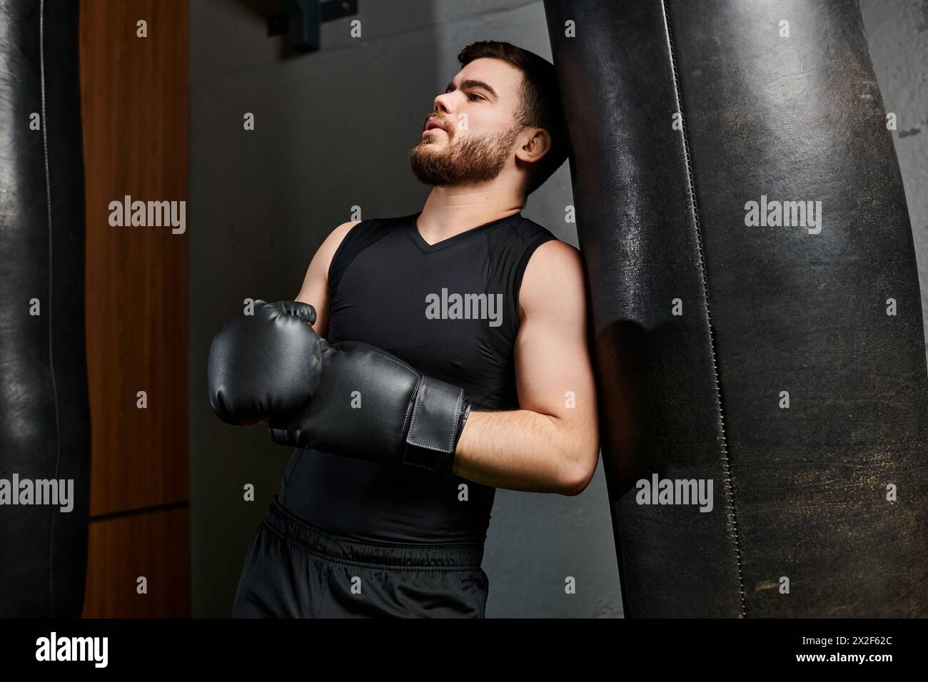 A handsome man with a beard wearing boxing gloves, intensely punching a ...