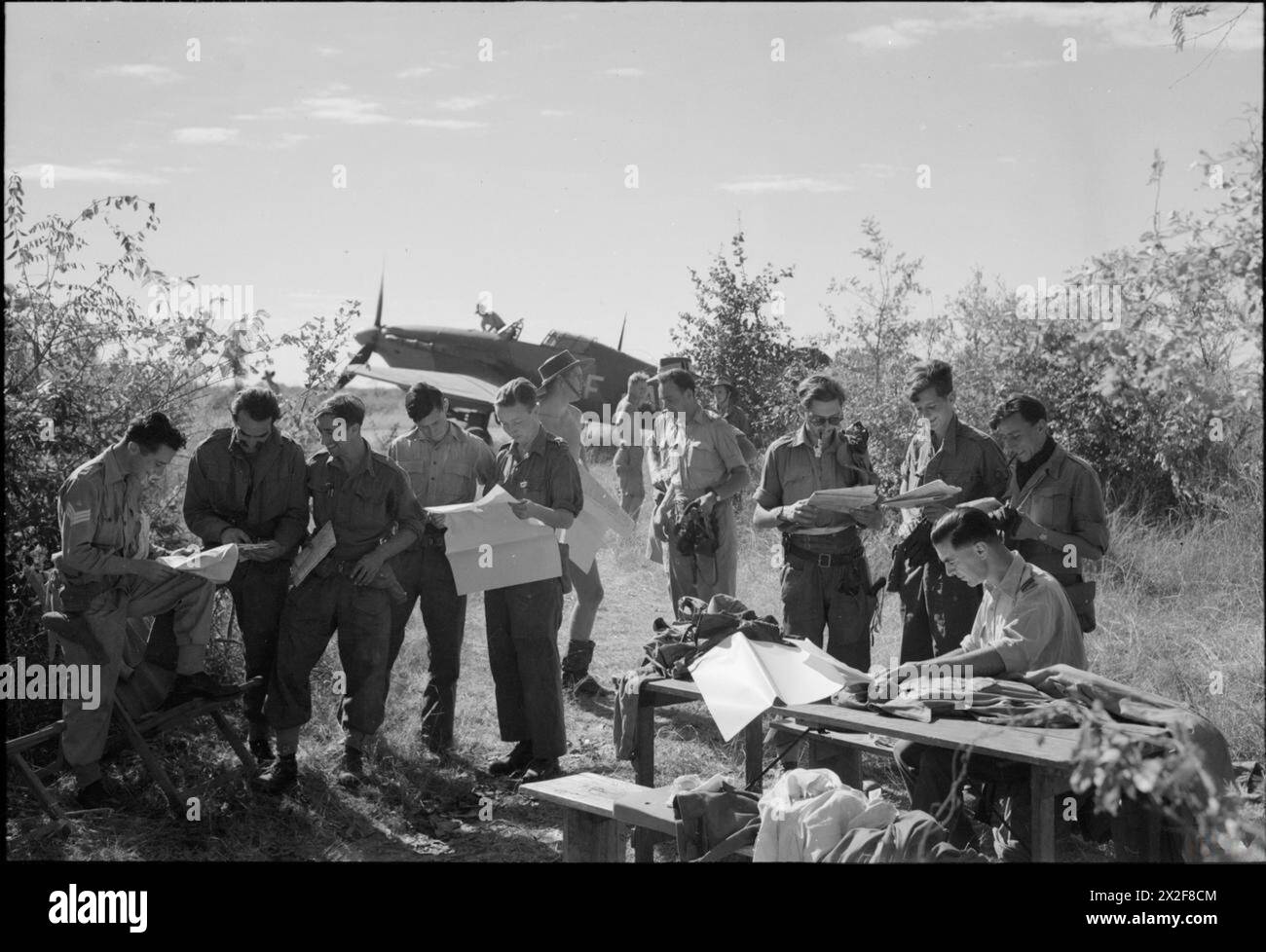 Pilots of 'A' Flight, No. 42 Squadron RAF study target maps at Onbauk ...