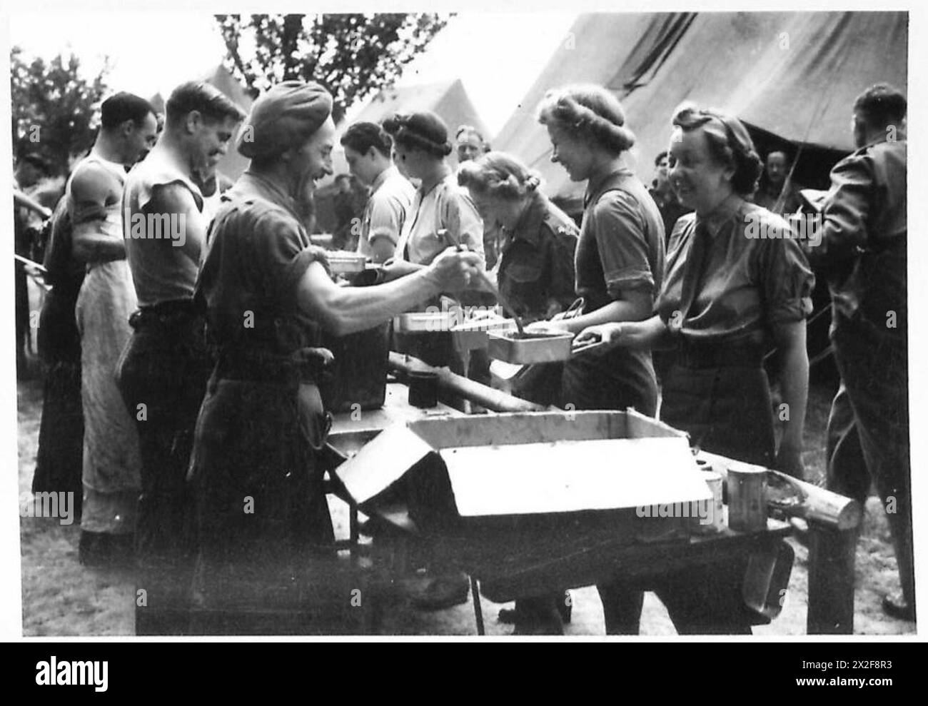 ATS "REDCAPS" - With mess tins, the girls queue at the cookhouse ...