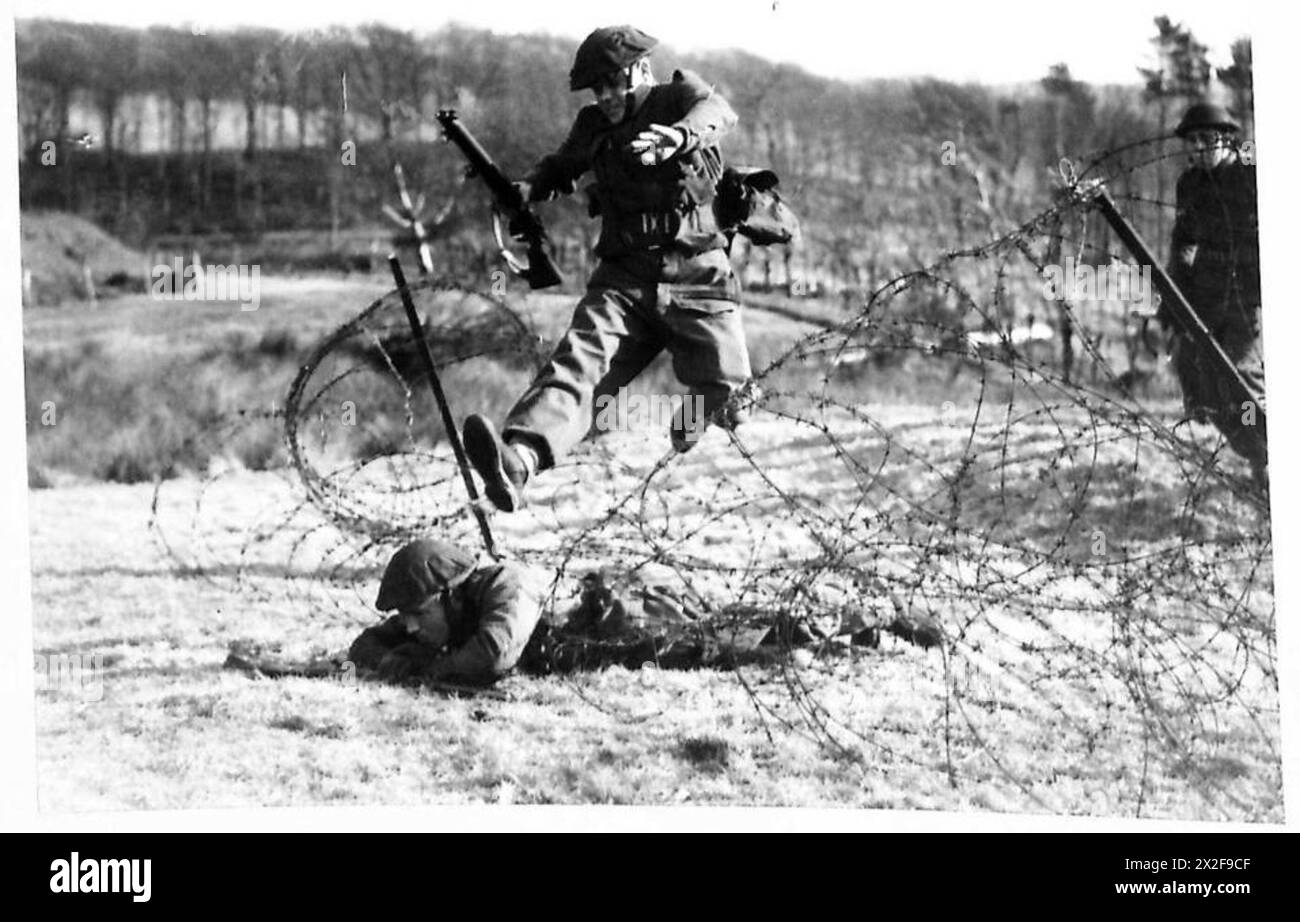 Commandos in training demonstrate a method for crossing barbed wire ...