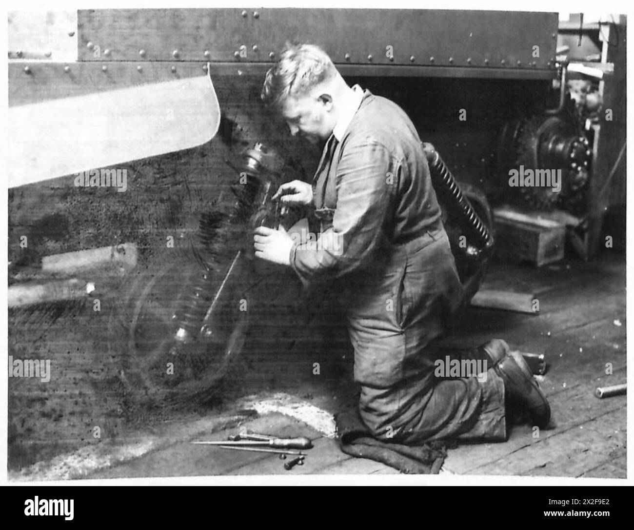 British Army personnel fit front bogey wheels to an armored carrier ...