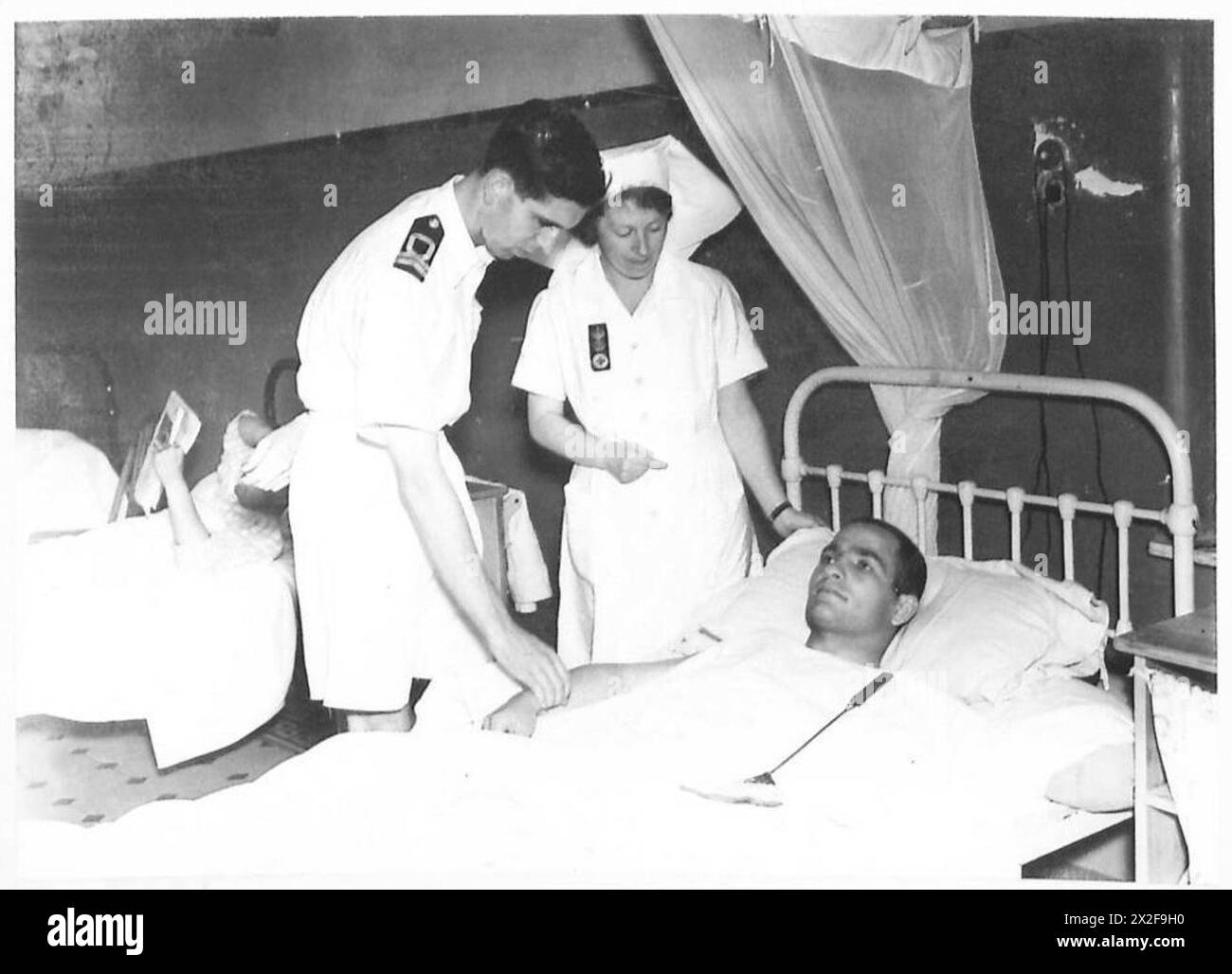 A British naval doctor examines a captured Italian pilot-officer in a ...