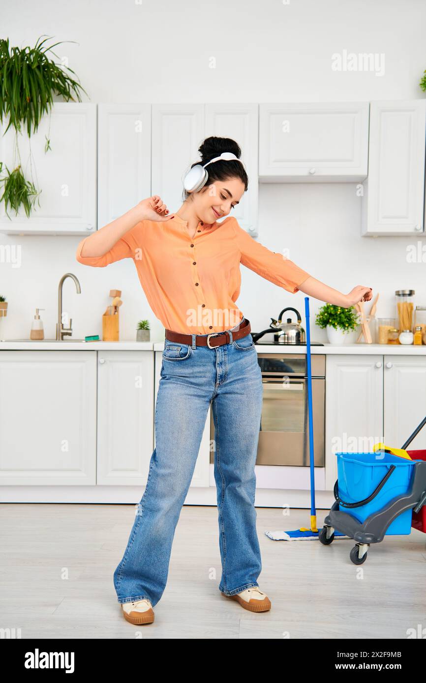 A stylish woman in casual attire energetically mopping the floor, with ...