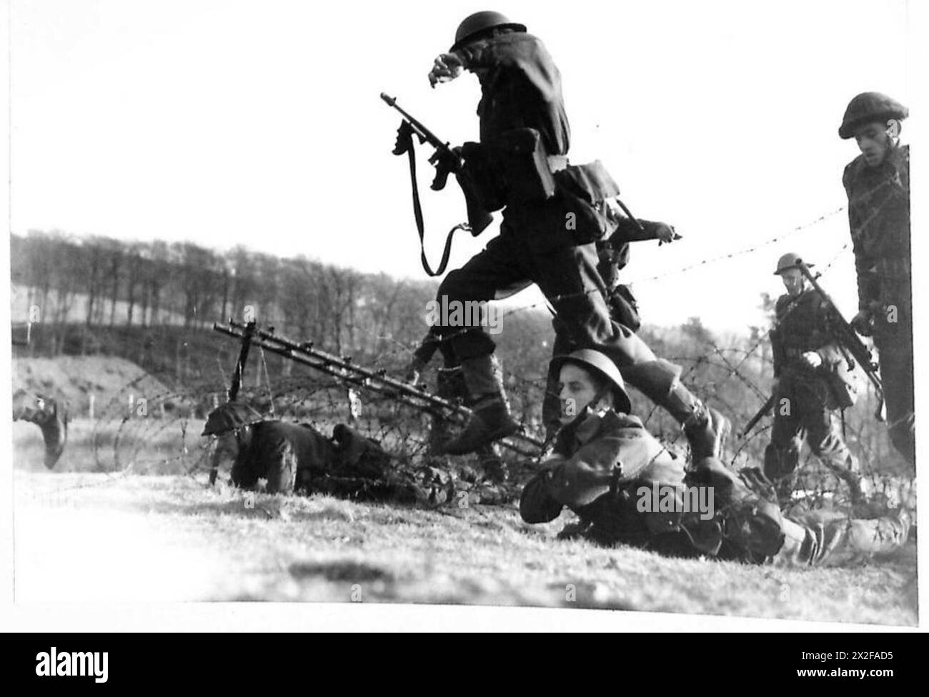 British Army commandos practice crossing barbed wire obstacles during ...