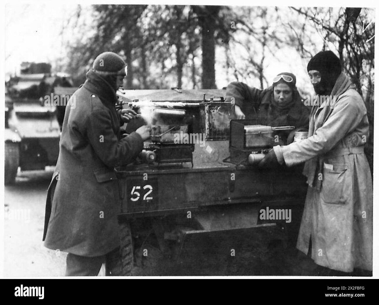 British Army tank personnel prepare a meal by the roadside during large ...