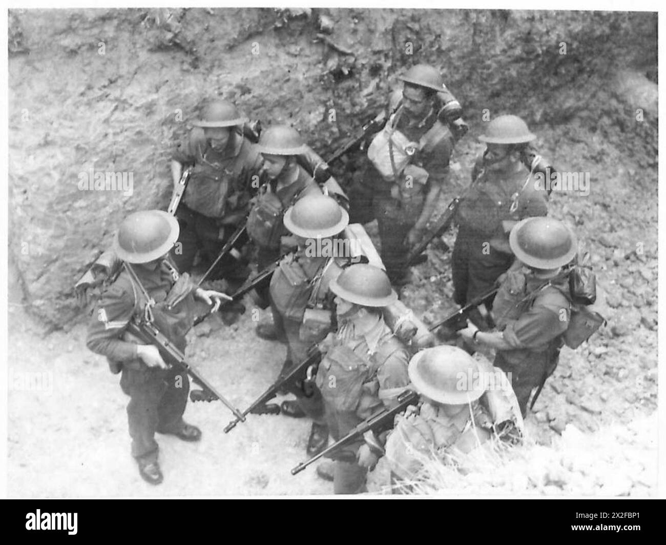 Royal Scots Fusiliers armed with Tommy guns wait in a trench for orders ...