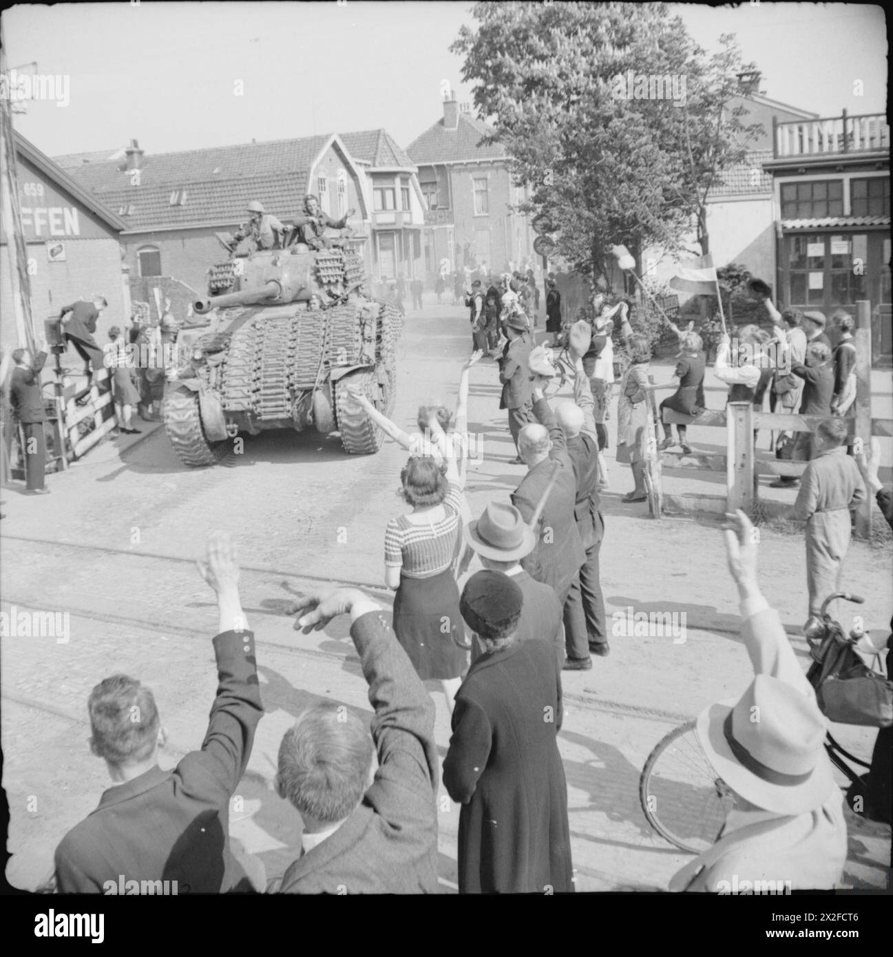 Dutch civilians observe and cheer a Sherman Firefly of the 5th Canadian ...