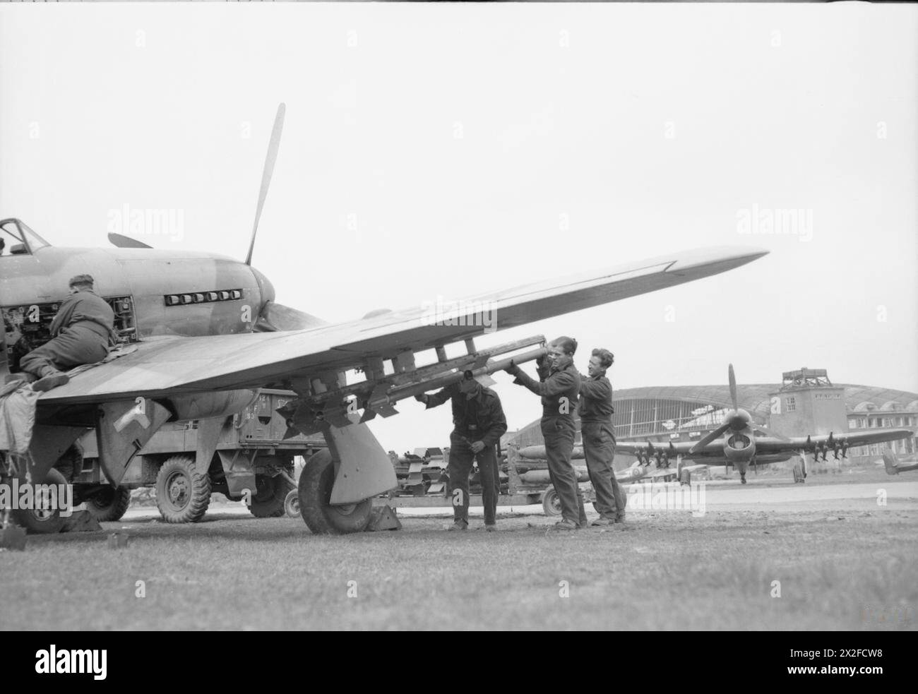 Armourers load 3-inch rocket projectiles onto a Hawker Typhoon Mark IB ...