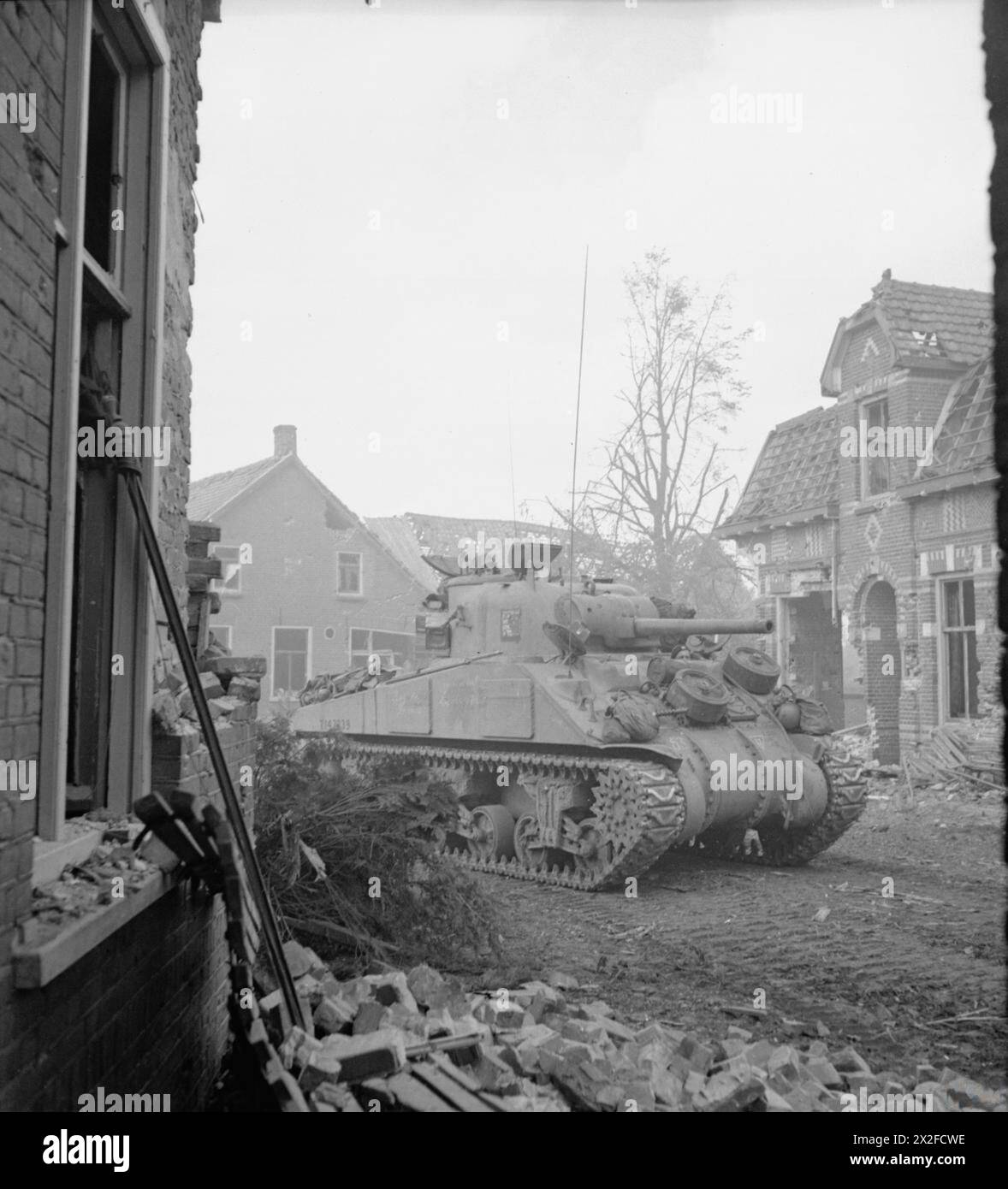 A Sherman command tank advances through Overloon as part of British ...