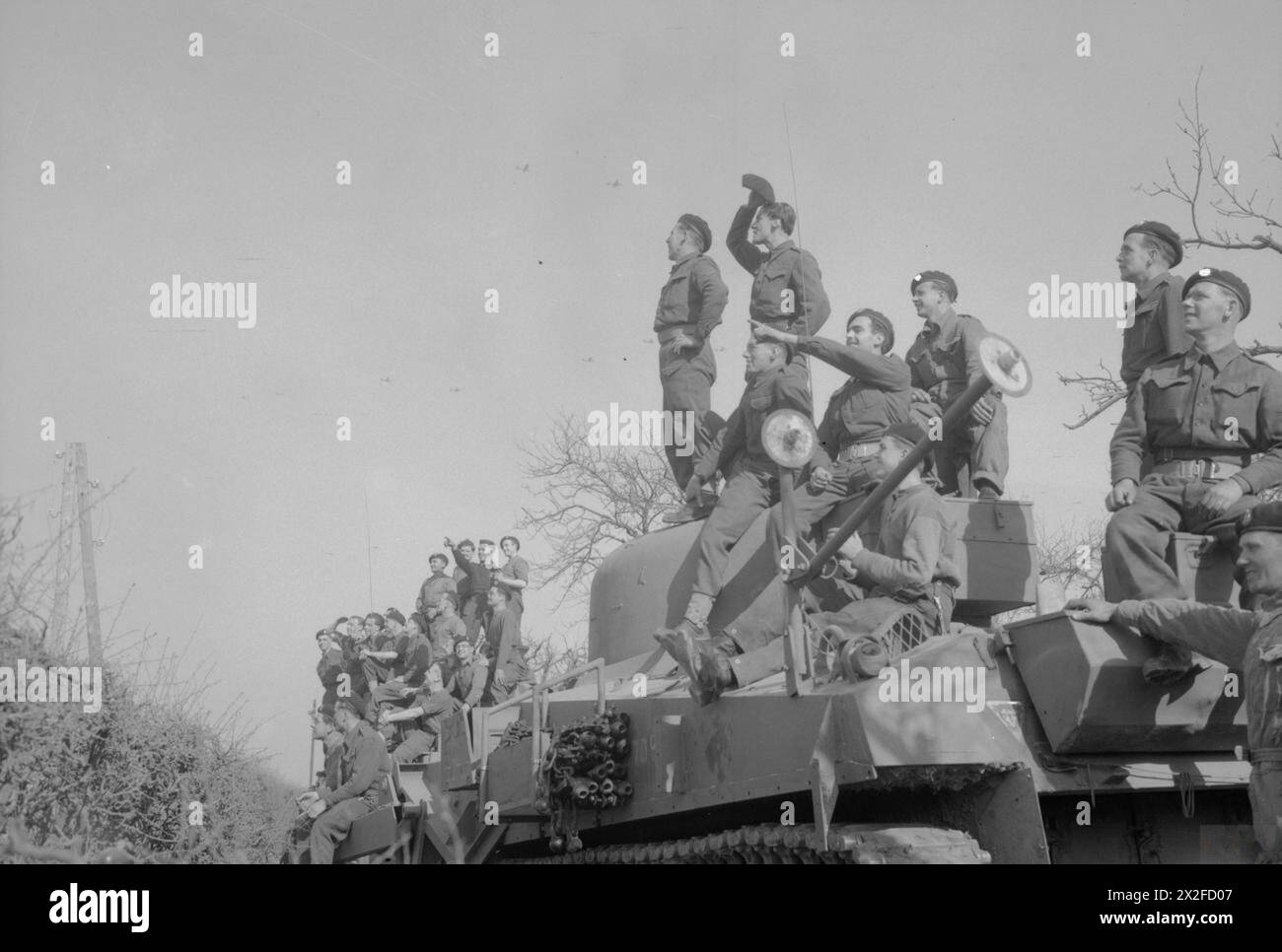 British Army troops stand on a Sherman Crab flail tank to observe ...