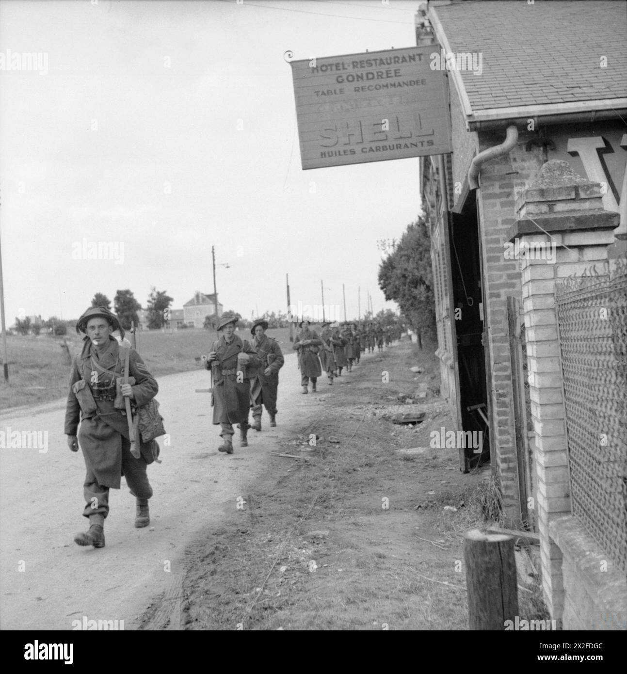British troops of the Gordon Highlanders pass the Hotel Restaurant ...