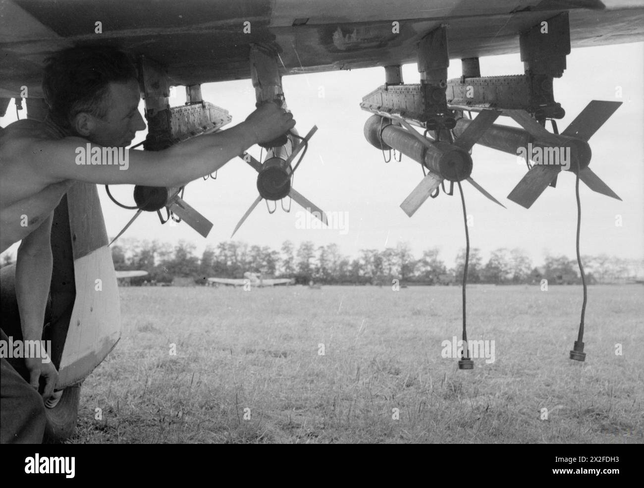 An armourer connects electrical plugs for 3-inch rocket projectiles on ...