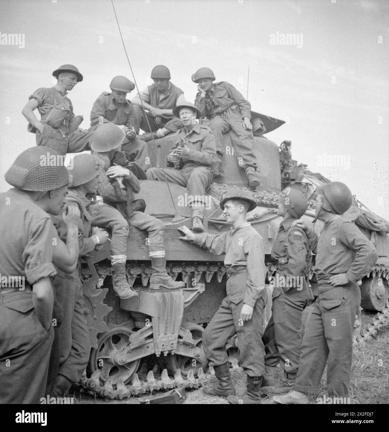 THE BRITISH ARMY IN NORMANDY 1944 - George Formby entertaining troops while seated on a Sherman ...