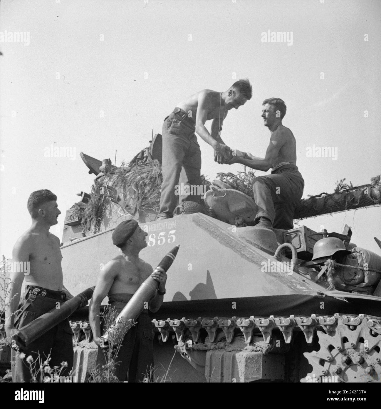A Sherman Firefly crew of the 1st Northamptonshire Yeomanry loads ...