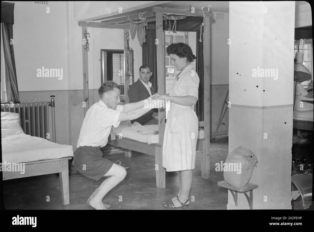 A wounded soldier performs squatting exercises with a nurse at the ...
