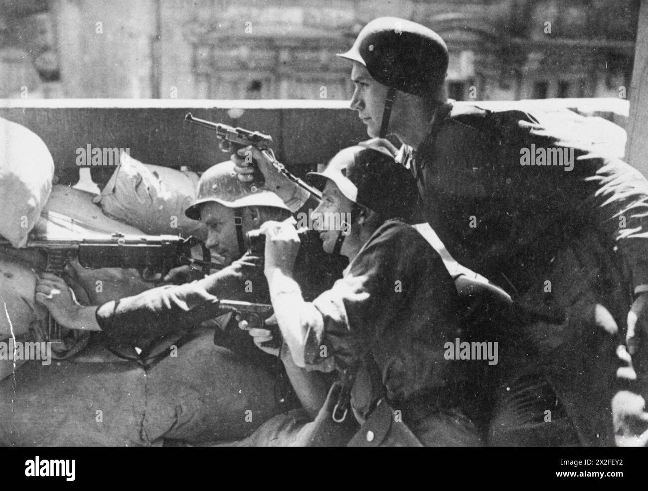 Soldiers of the Home Army observe enemy positions from behind a street ...