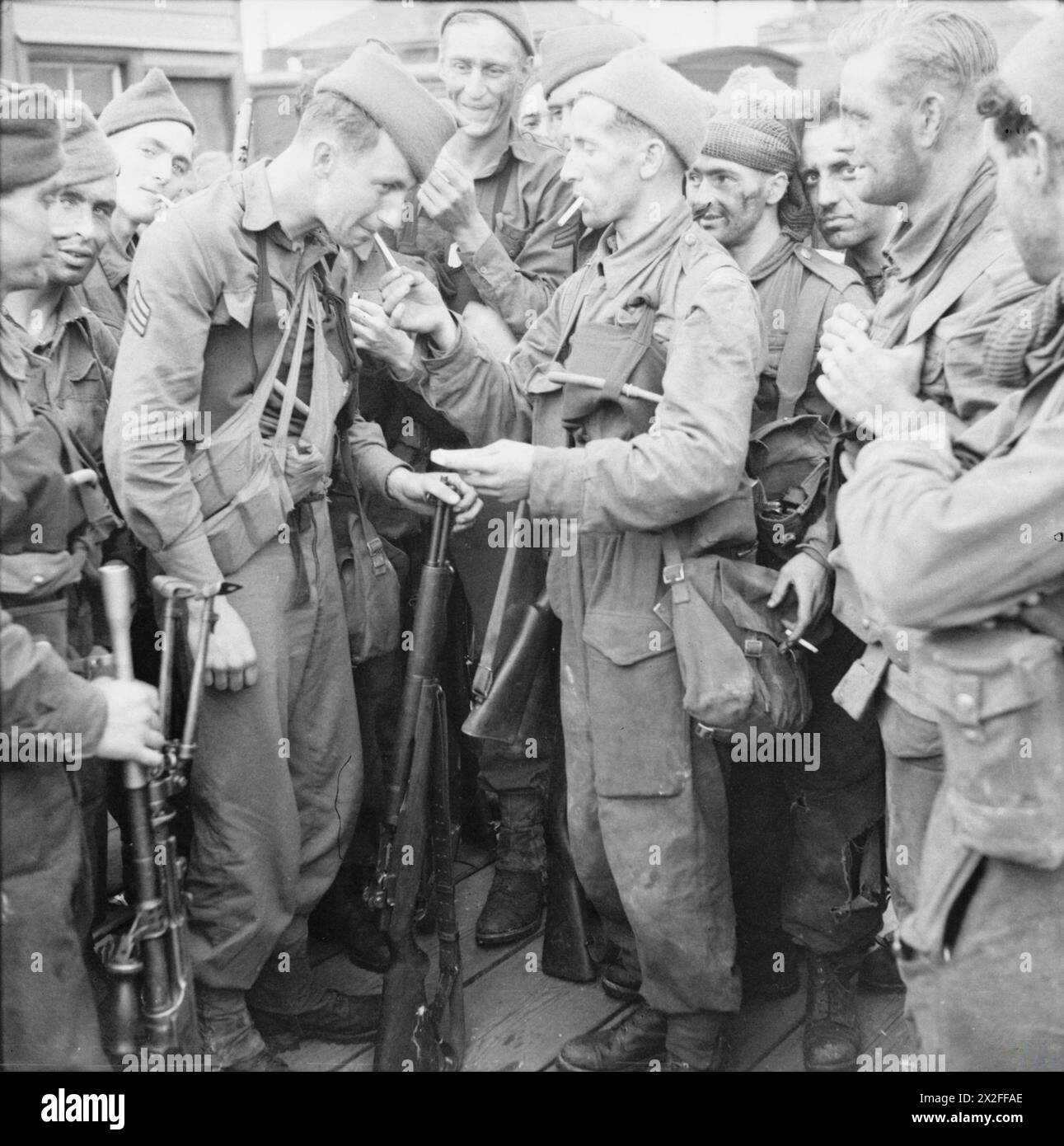 An American soldier at Newhaven receives a light from a comrade after ...