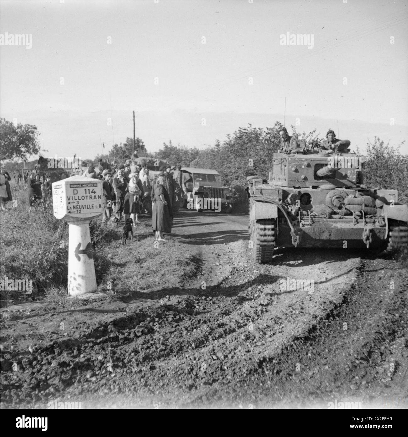 French civilians watch a Cromwell tank and other vehicles of the 2nd ...