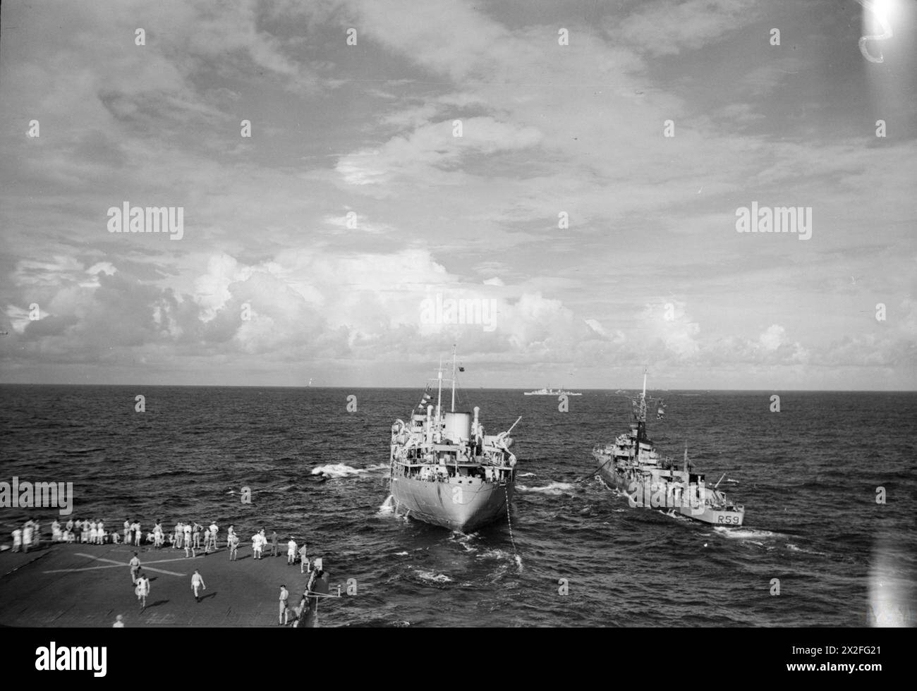 HMS Empire Savage, a fleet auxiliary, refuels the destroyer HMS Wakeful ...