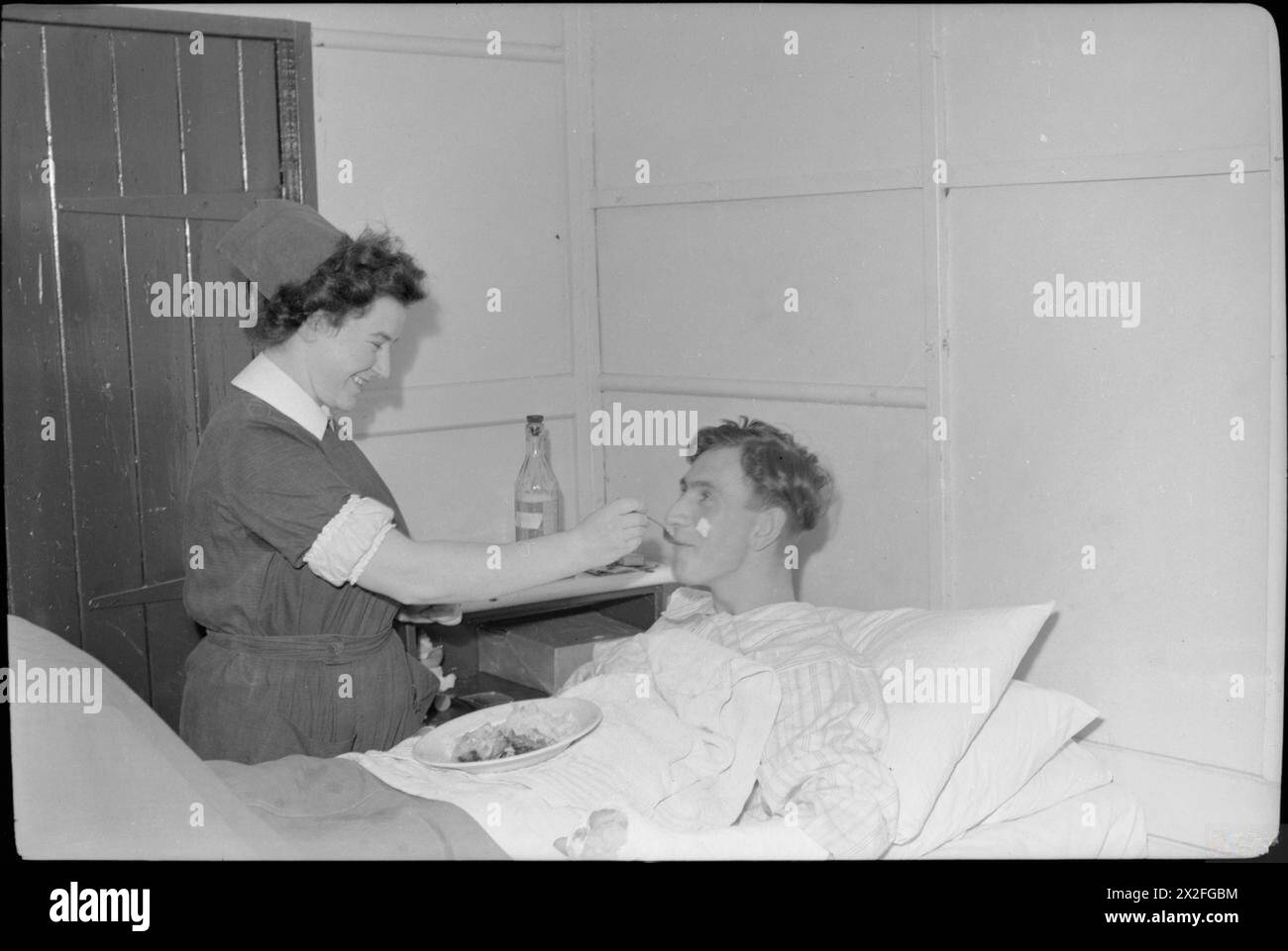 Private N. Jones, wounded in both arms and one leg in Normandy, is fed ...