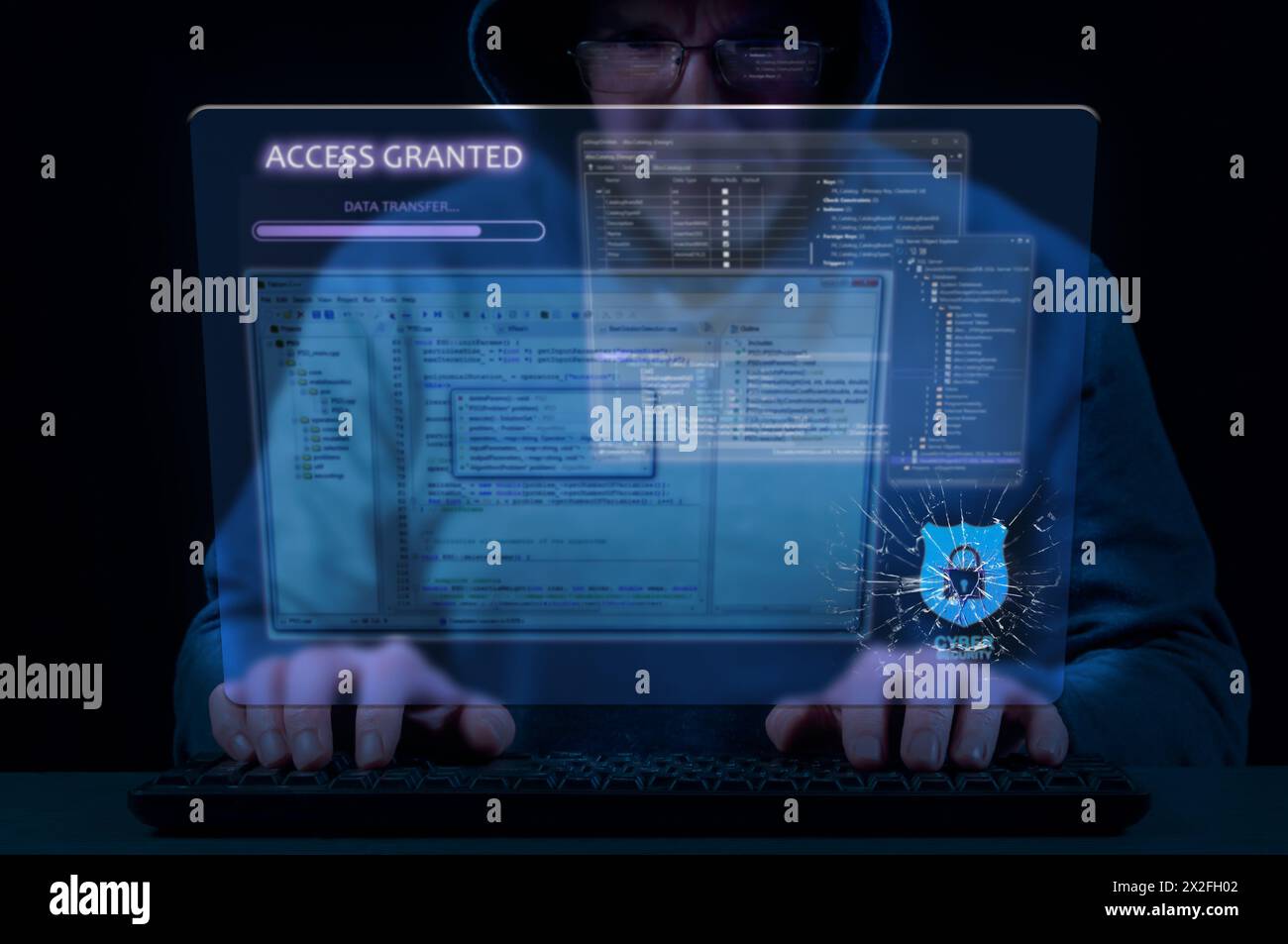Man in hood on dark background uses keyboard and virtual screen to ...