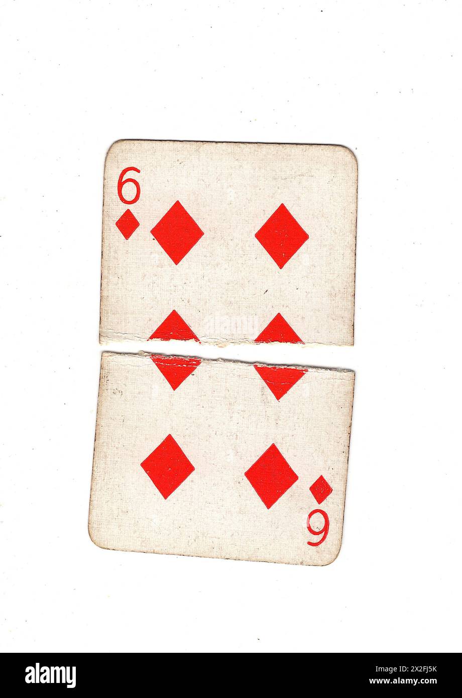 A vintage, well used six of diamonds playing card torn in half on a ...