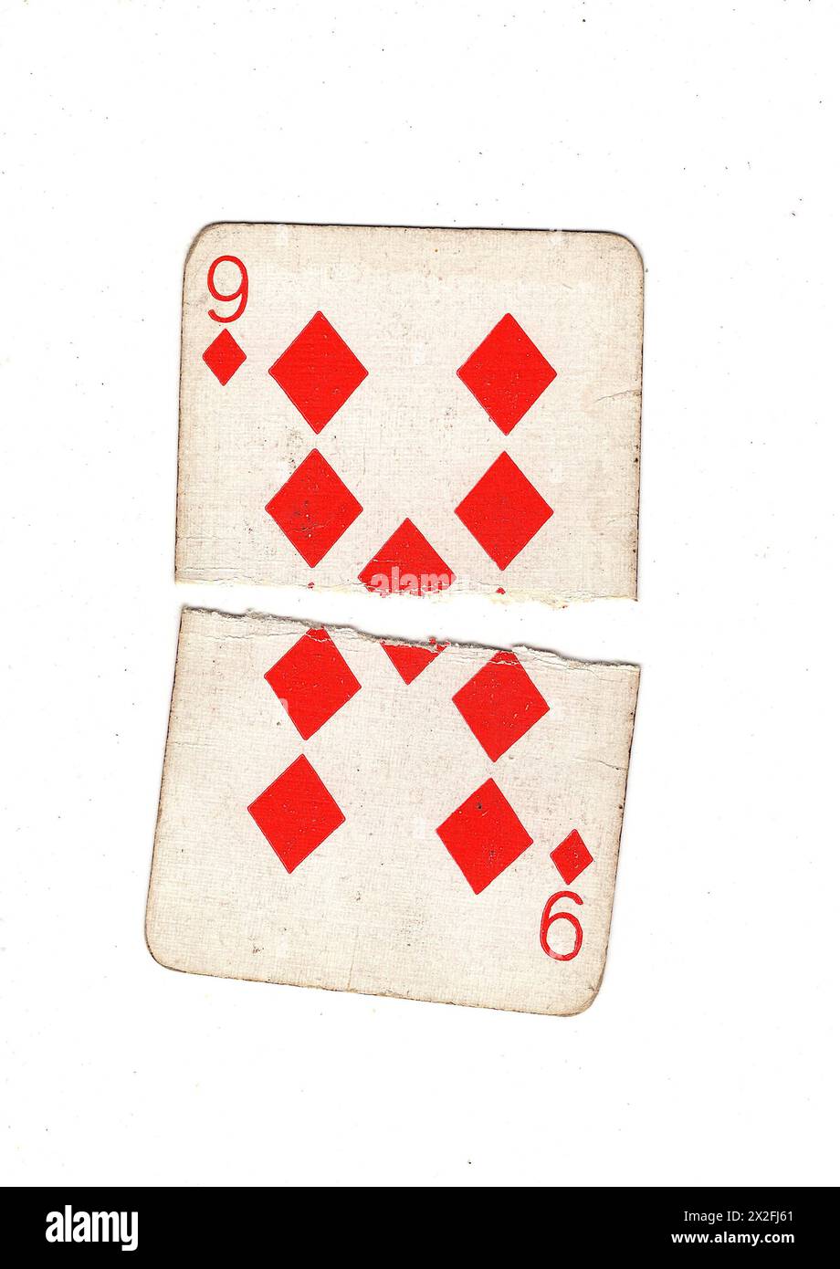A vintage, well used nine of diamonds playing card torn in half on a ...