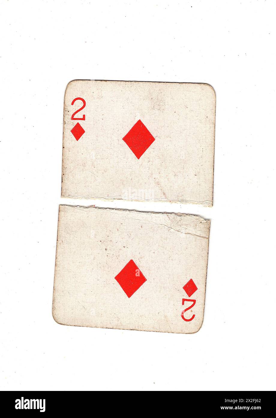 A vintage, well used two of diamonds playing card torn in half on a ...