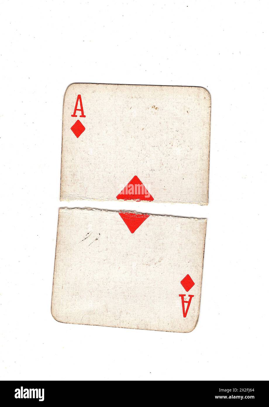 A vintage, well used ace of diamonds playing card torn in half on a ...