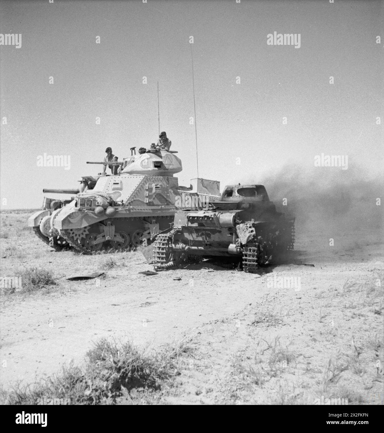 A Grant tank of the British Army passes a burning German PzKpfw I tank ...