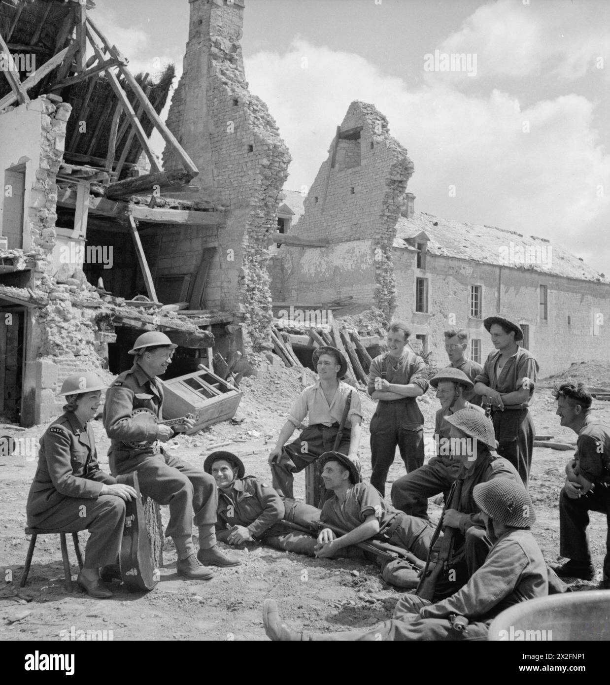 GEORGE FORMBY IN NORMANDY - George Formby and Beryl entertain a small group of Royal Engineers ...