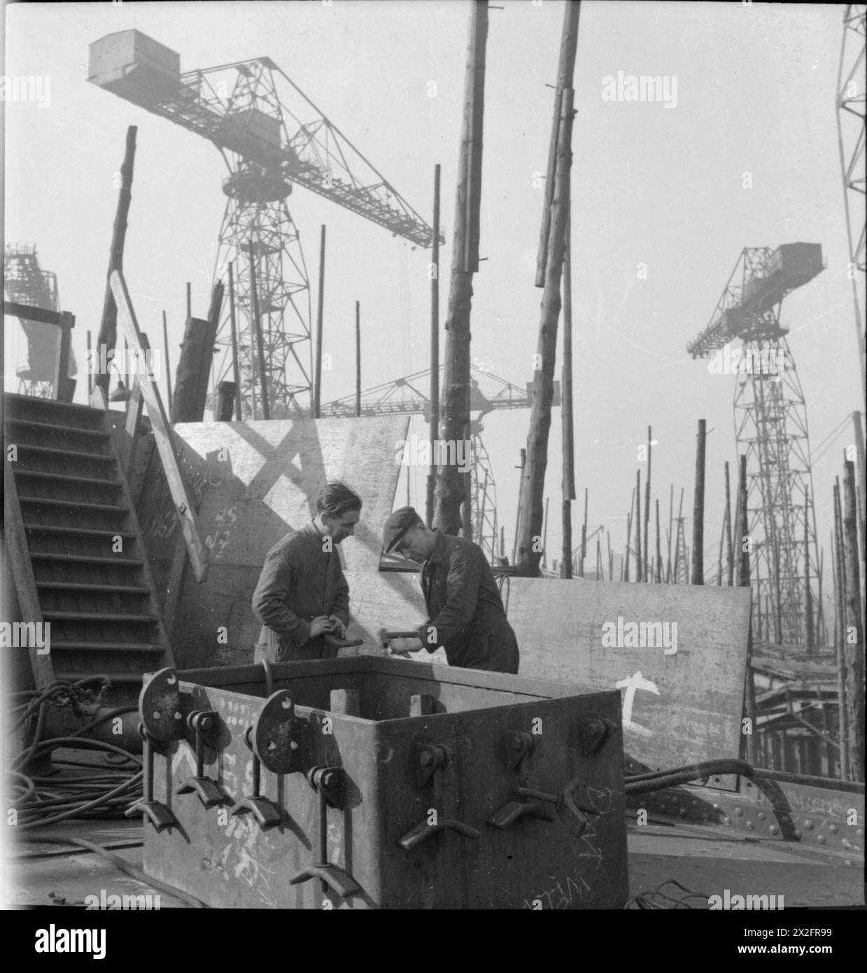 Cecil Beaton photographed men working on an oil hatch aboard a ship at ...