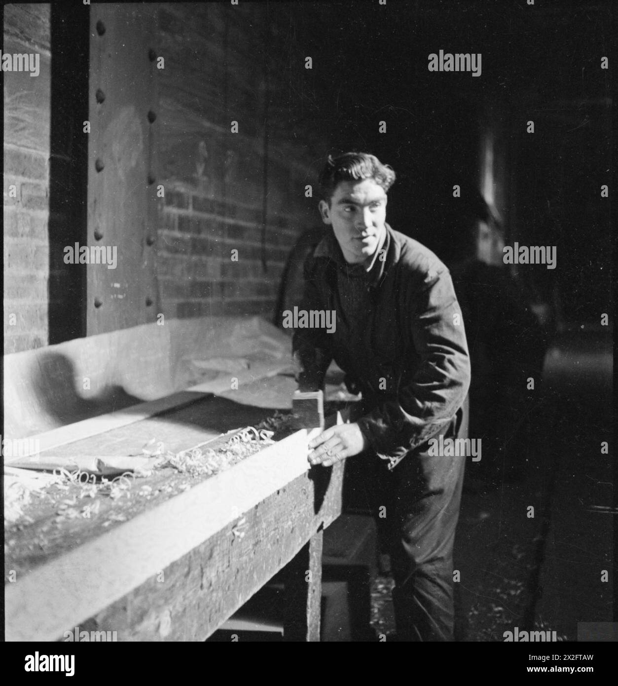 A carpenter works in a mould loft at the Tyne shipyards in 1943. The ...