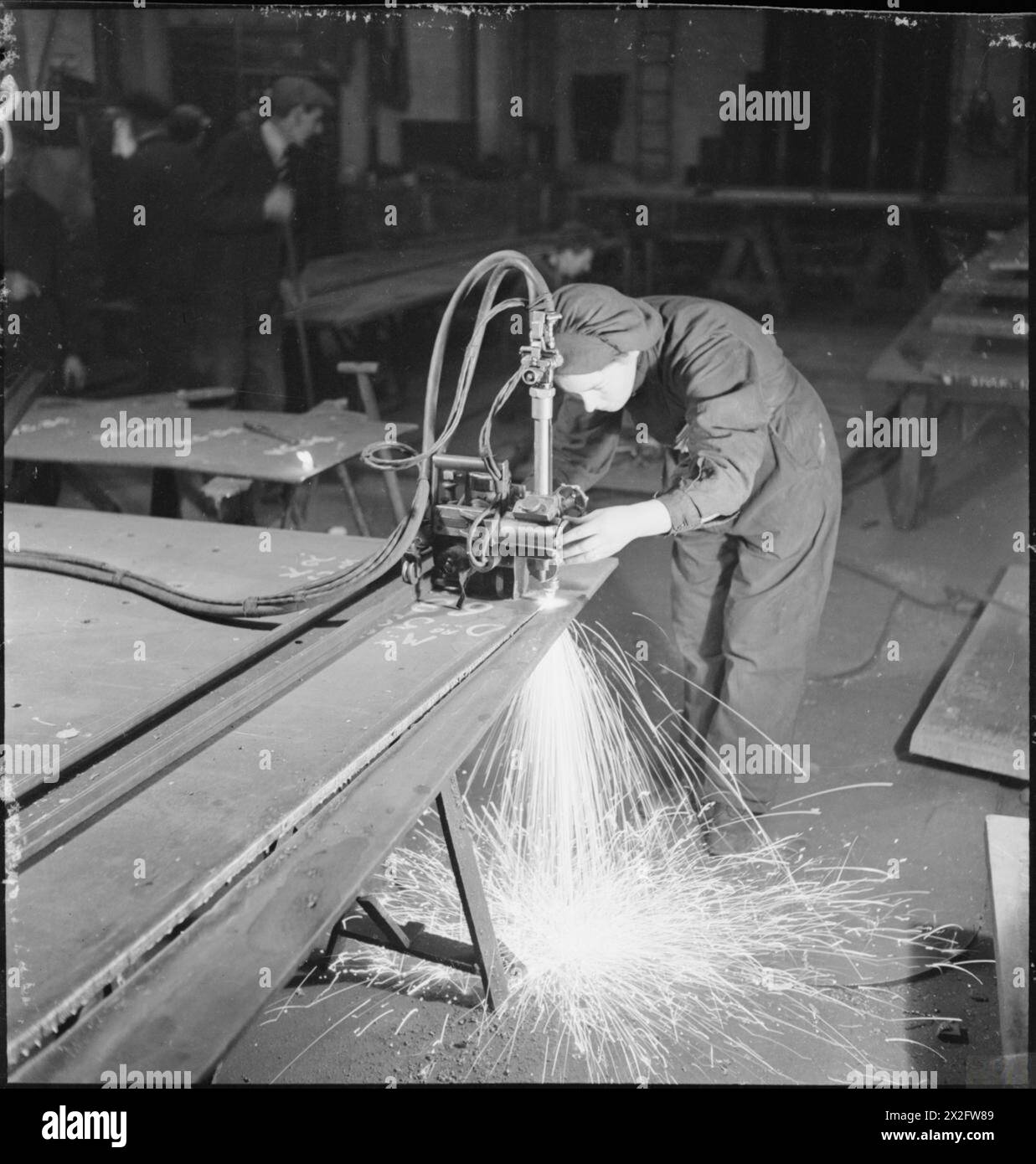 WAR INDUSTRY: OXY-ACETYLENE CUTTING, UK, 1942 - A woman war worker uses ...